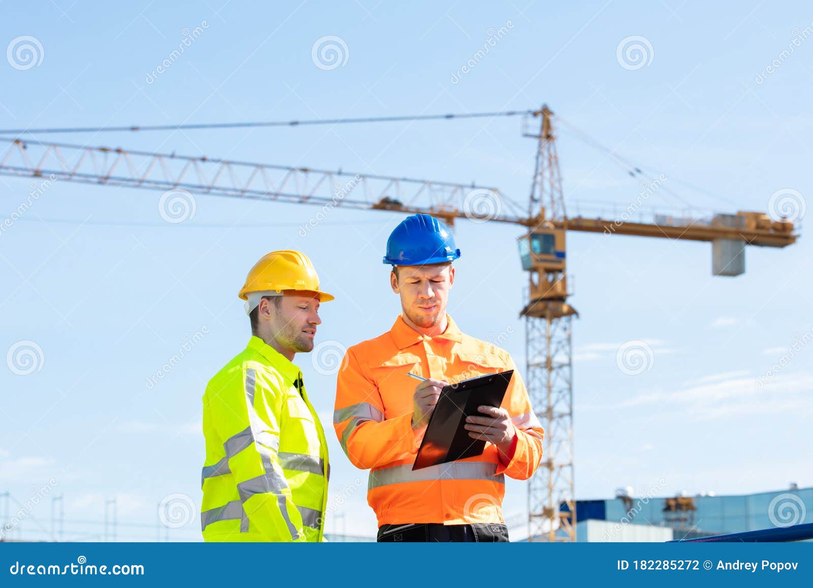 Two Male Engineers with Clipboard Working at Construction Site Stock ...