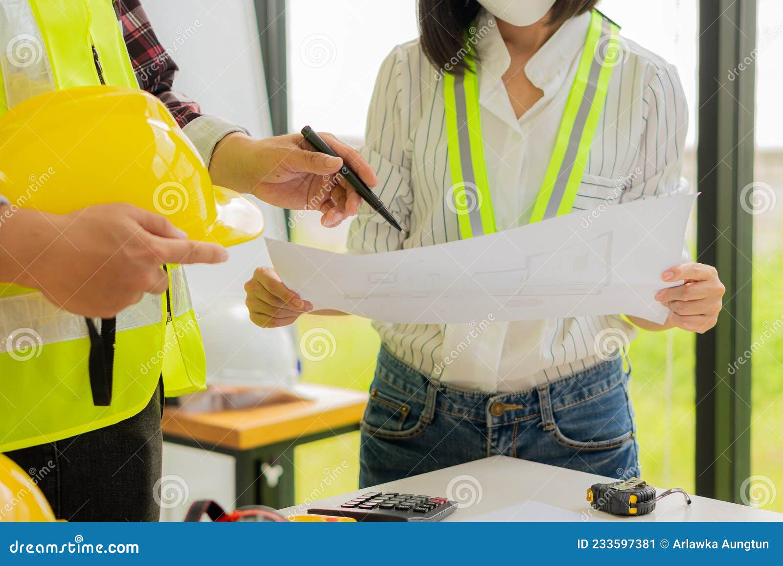 Two Male and Female Engineers Working on Blueprints for the Project ...