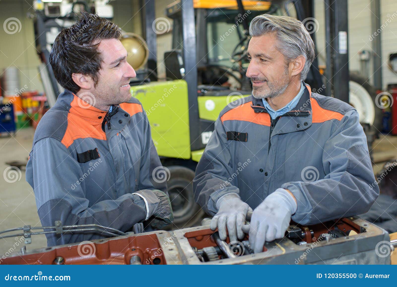 Two Male Mechanics Chatting Stock Photo - Image of tradesman, blue ...