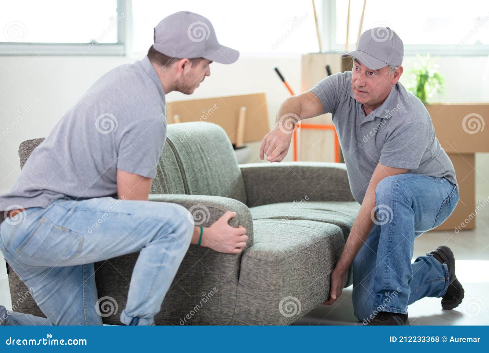 Two Male Movers Carrying Sofa in Clients House Stock Photo - Image of ...