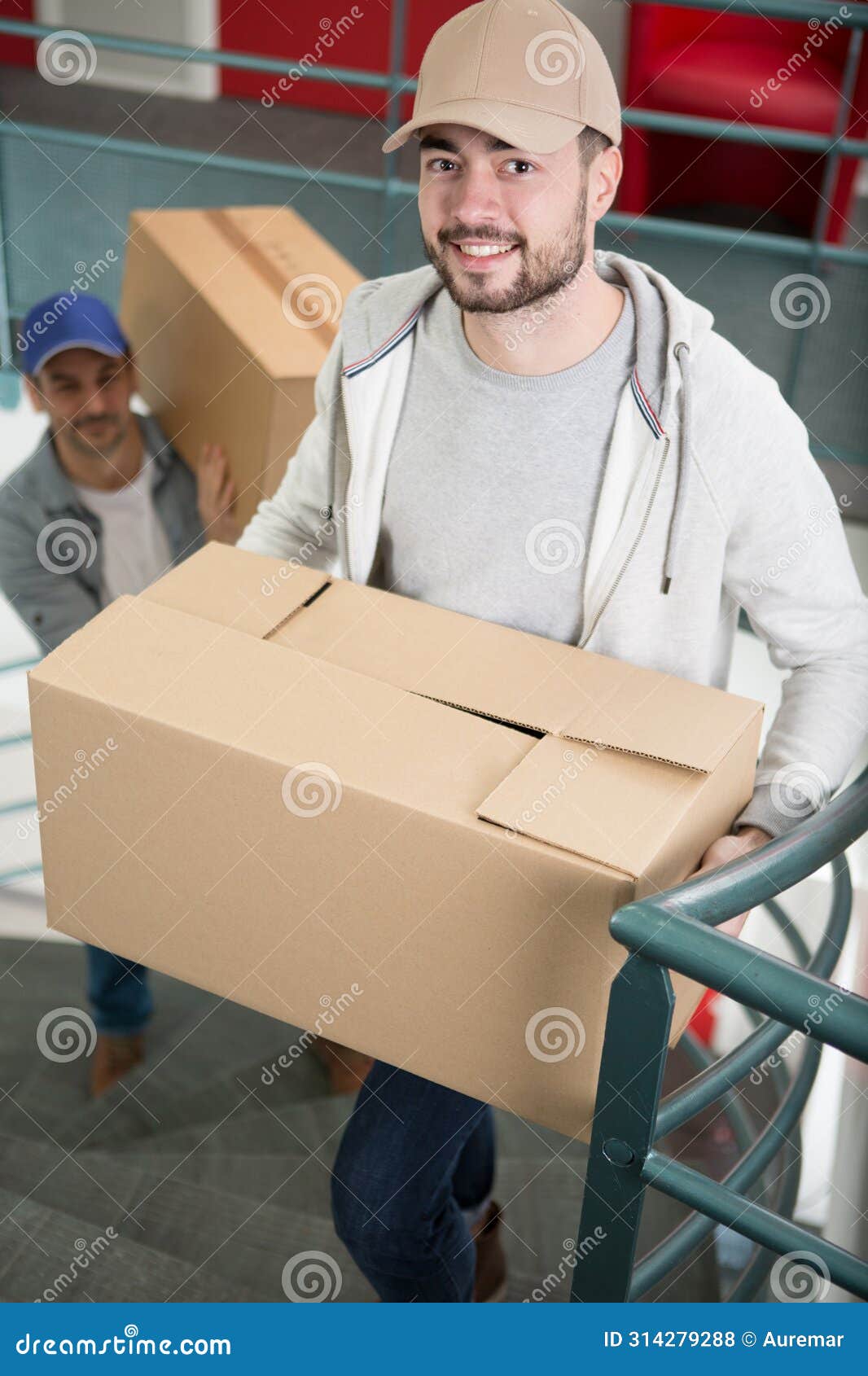 Two Male Movers in Uniform Carrying Cardboard Boxes on Staircase Stock ...