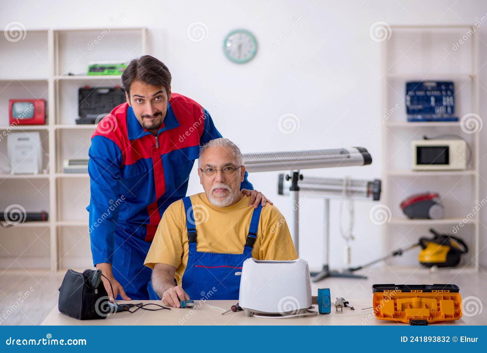 Two Male Repairmen Working at Workshop Stock Photo - Image of ...