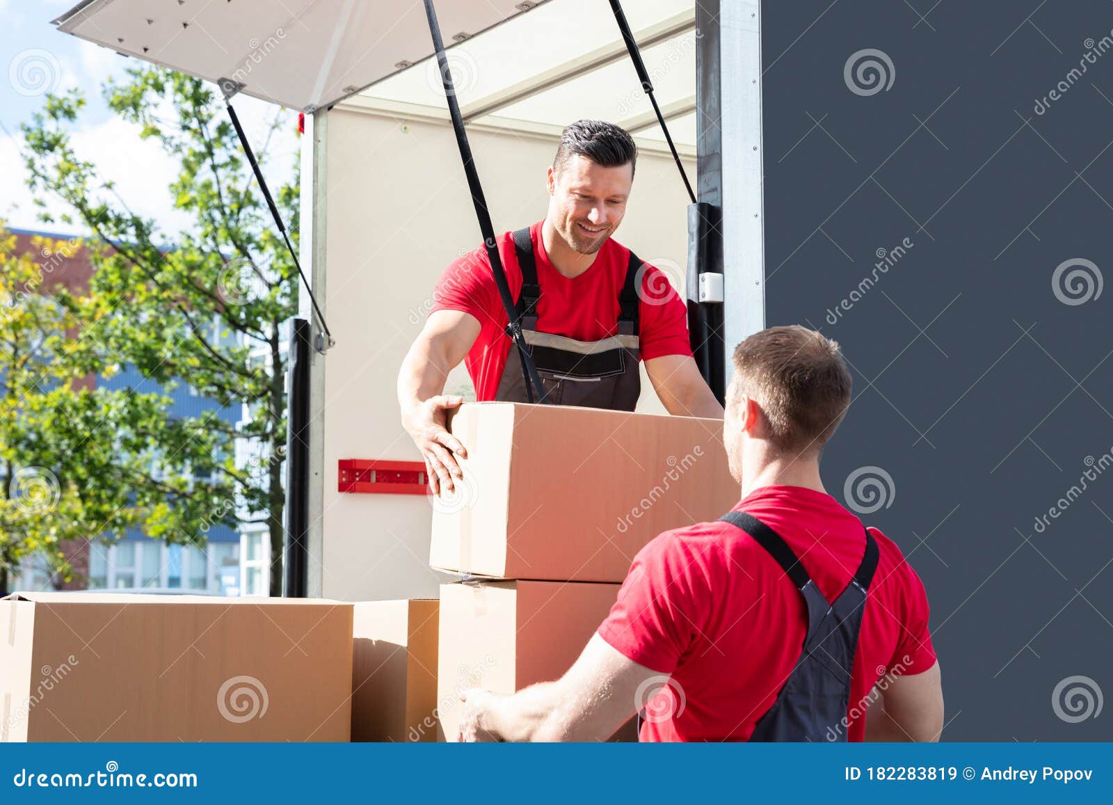 Two Male Worker Loading the Cardboard Boxes in Moving Truck Stock Image ...
