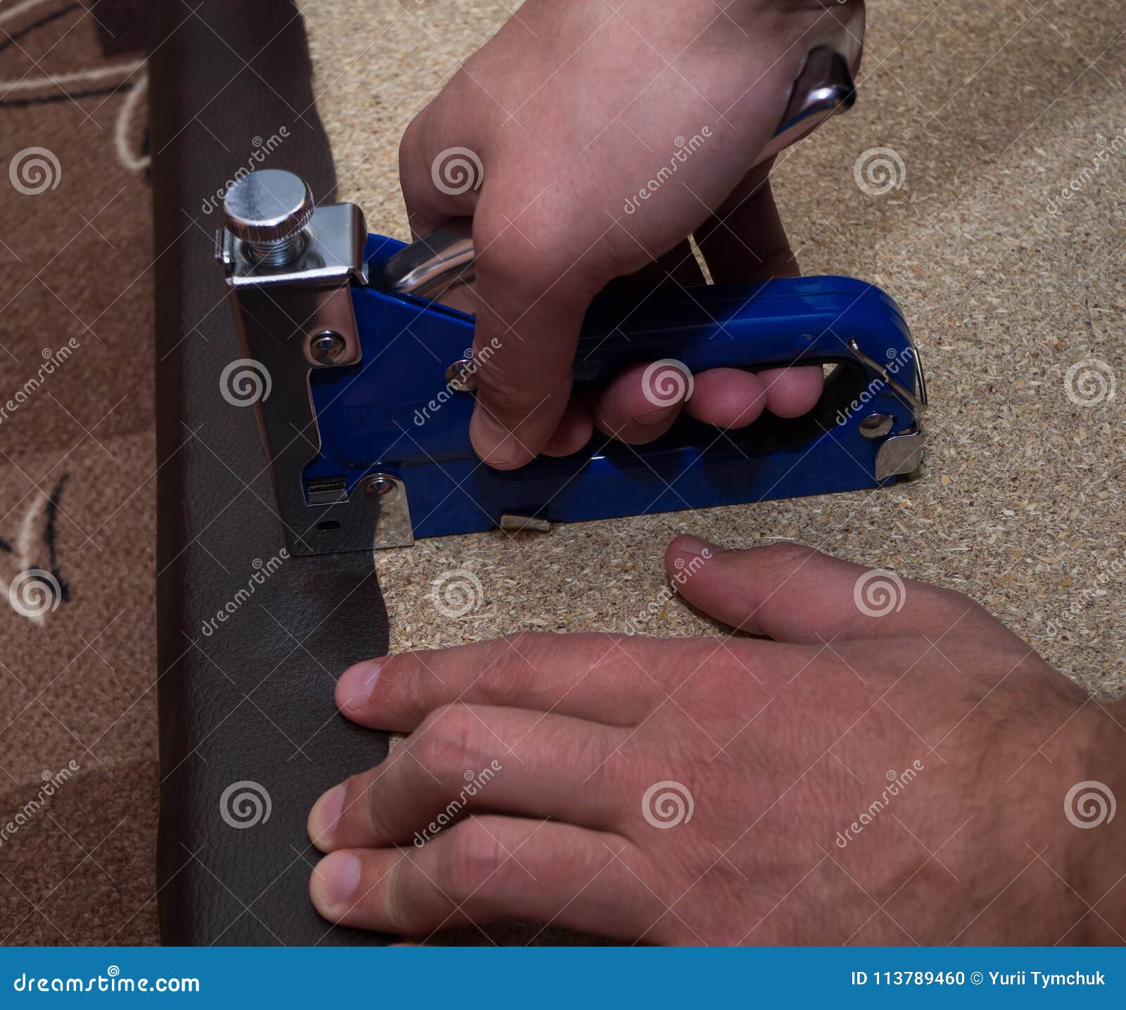 Two Man Hands Using Stapler Upholstering Paricle Board with Leatherette ...