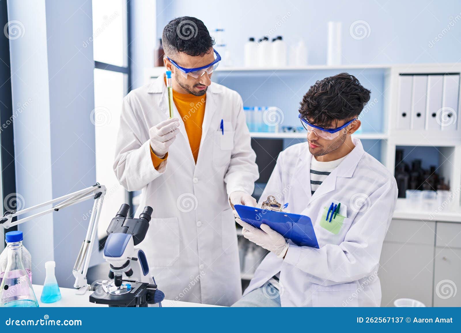 Two Man Scientists Holding Test Tubes Write on Clipboard Working at ...