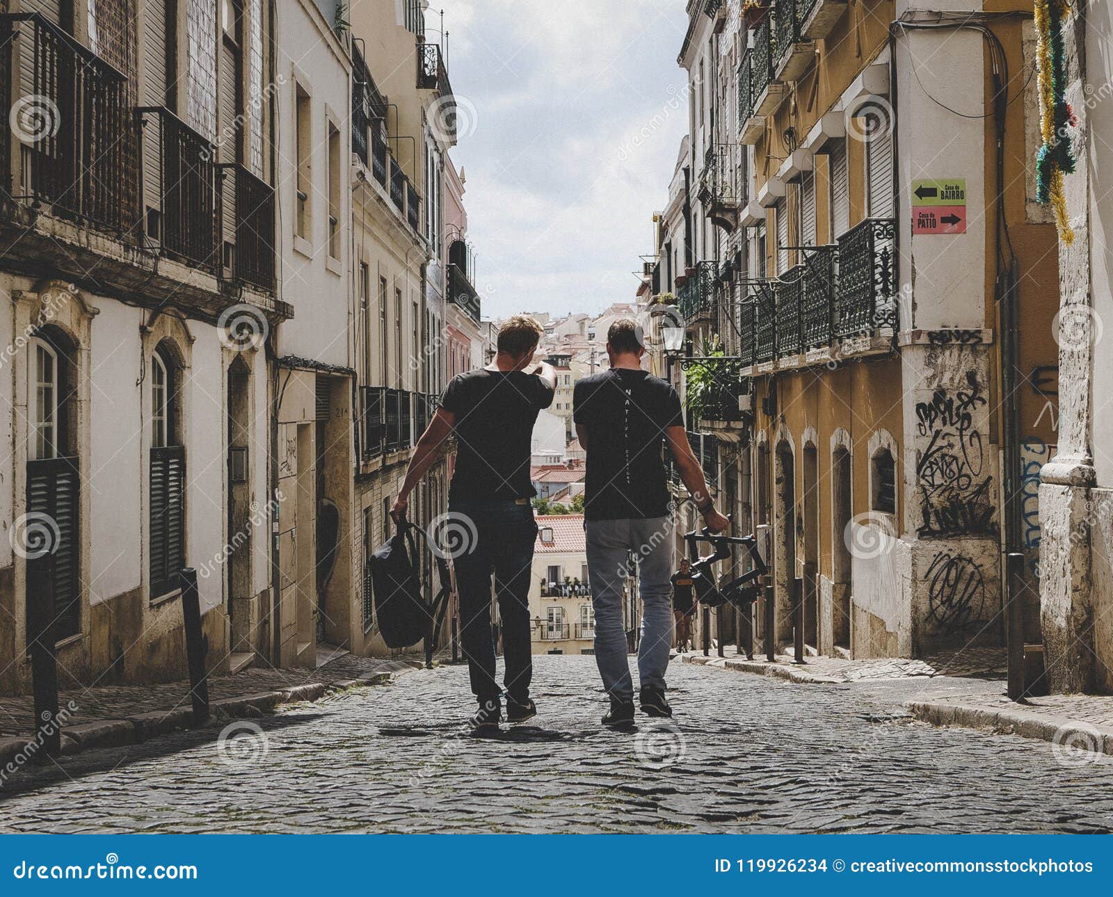 Two Man Walking In Between Of Buildings Toward With Concrete Building ...