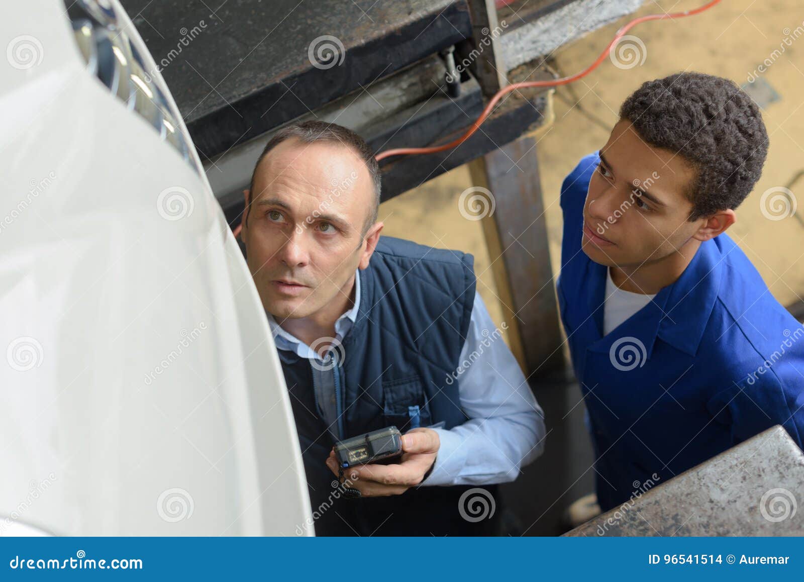 Two Mechanics Repairing Car in Garage Under Car Stock Photo - Image of ...