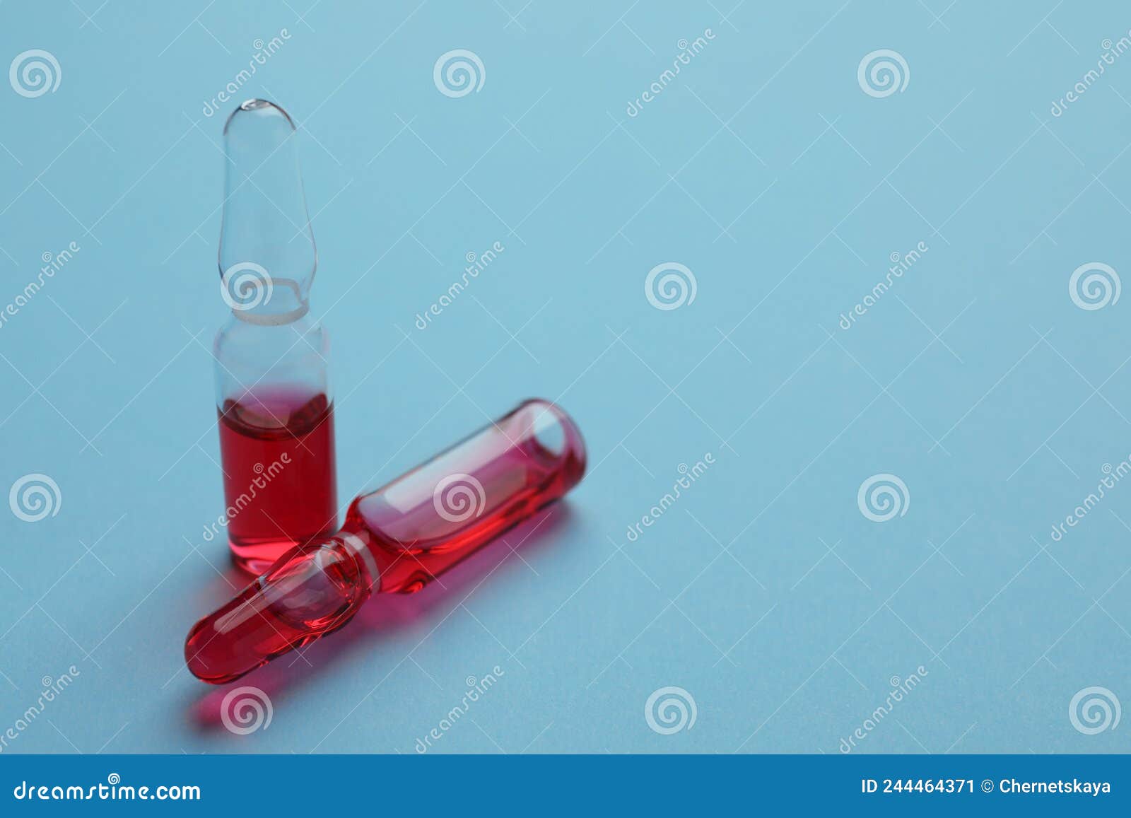 Two Medical Ampoules with Solution on Light Blue Background. Space for ...