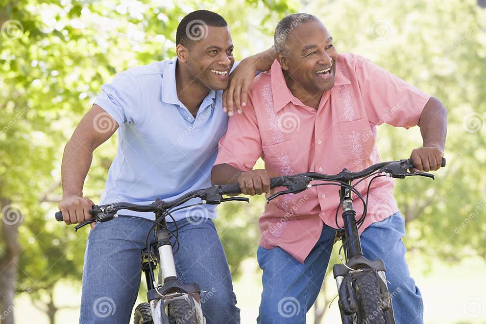 Two Men on Bikes Outdoors Smiling Stock Photo - Image of father, length ...