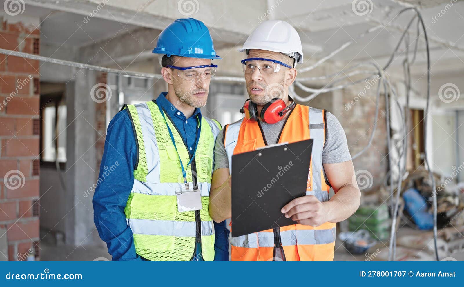 Two Men Builders Reading Document Speaking at Construction Site Stock ...