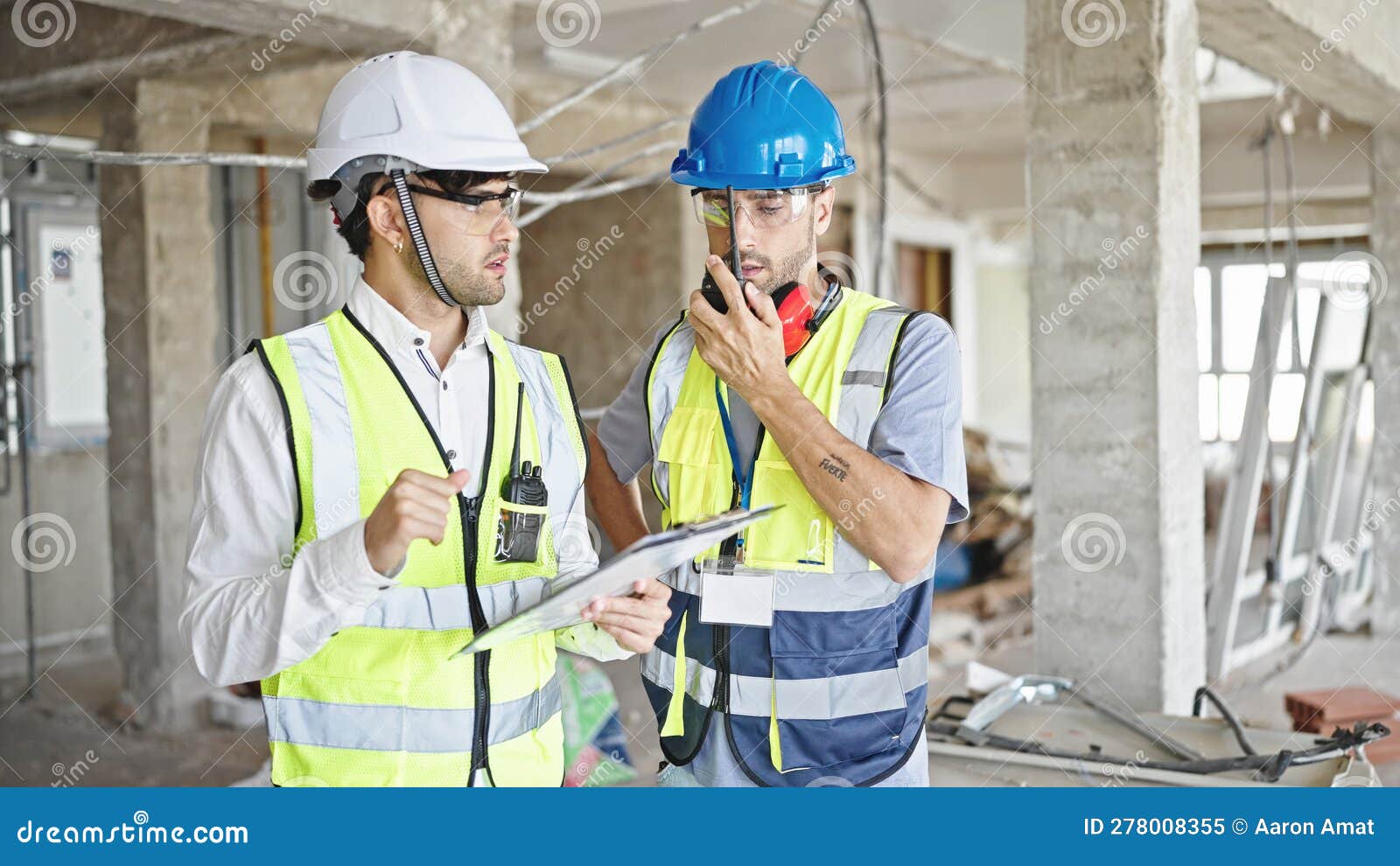 Two Men Builders Talking on Walkie Talkie Reading Document at ...