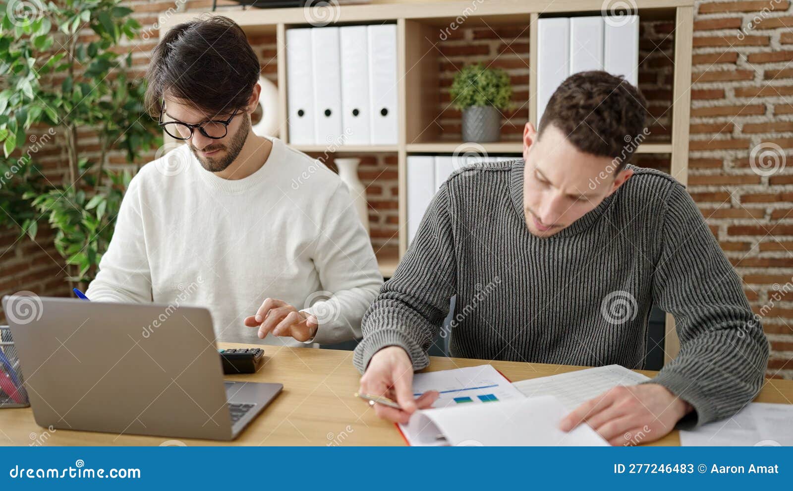 Two Men Business Partners Using Laptop Writing on Document Working at ...