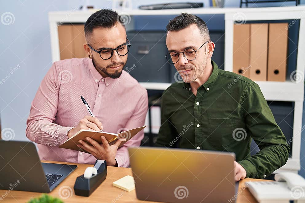 Two Men Business Workers Using Laptop Writing on Notebook at Office ...
