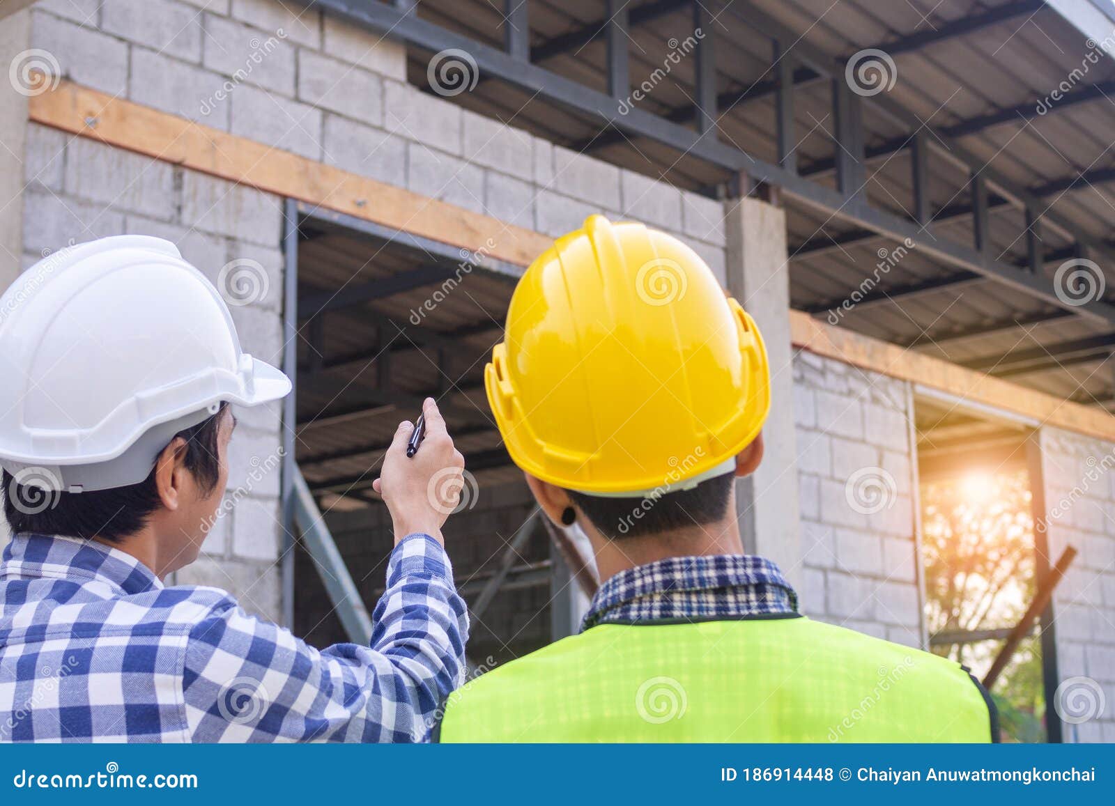 Two Men on Construction Site Wearing Hard Hats. Standing and Talking ...