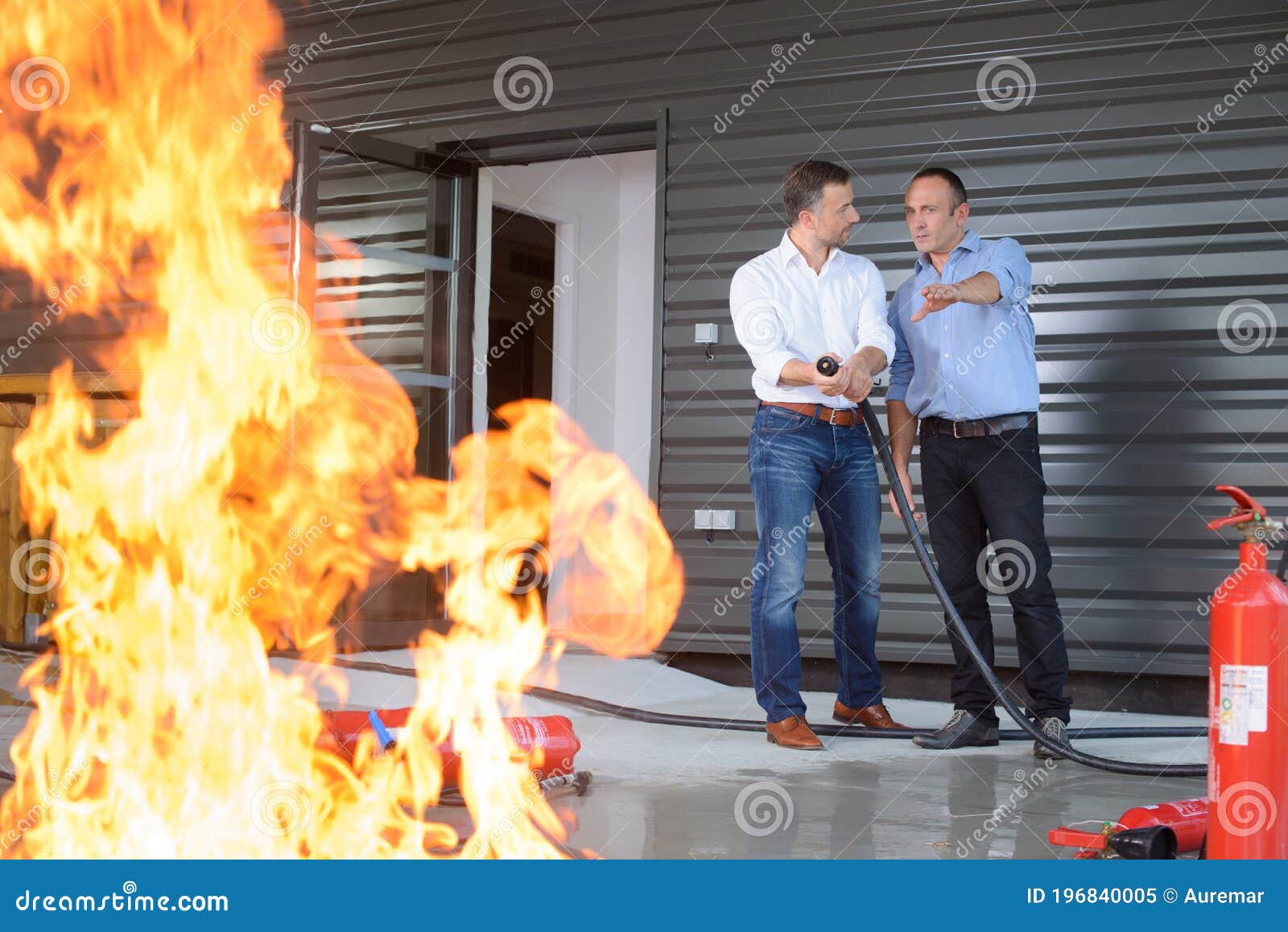 Two men controlling fire stock image. Image of pressure - 196840005