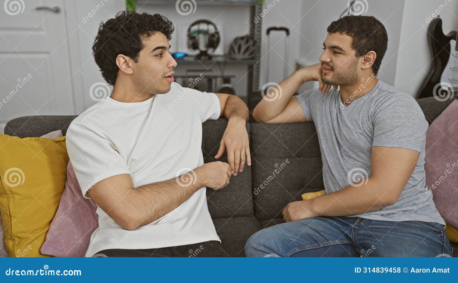 Two Men Conversing Comfortably on a Sofa in a Modern Living Room Stock ...