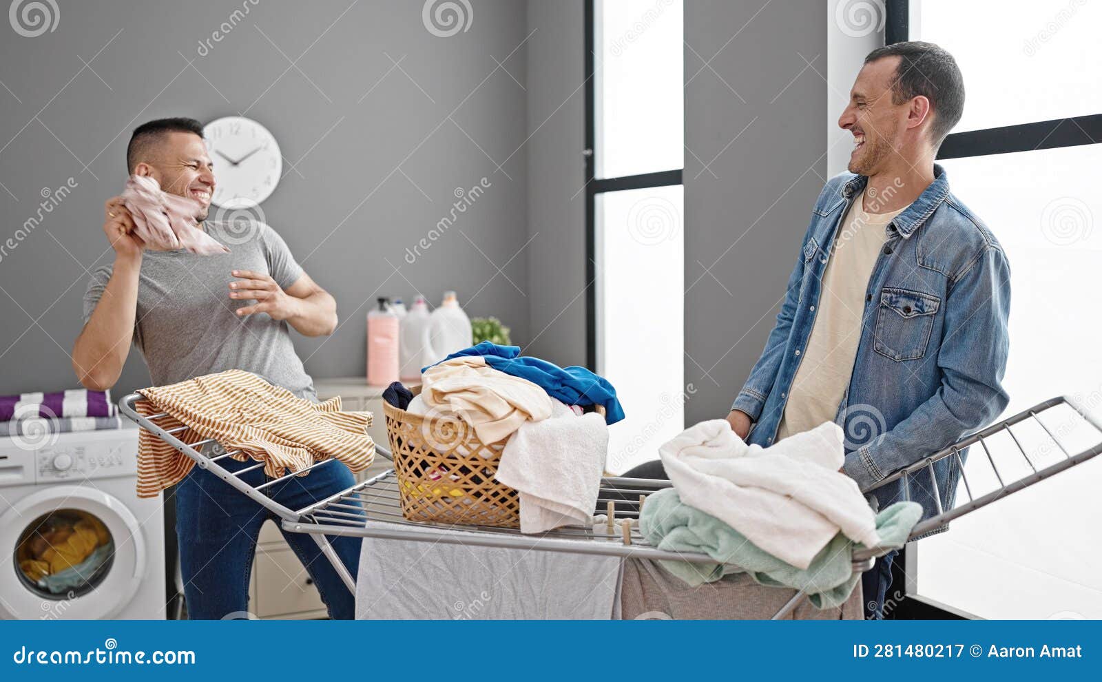 Two Men Couple Doing Laundry Throwing Clothes at Laundry Room Stock Image - Image of ...