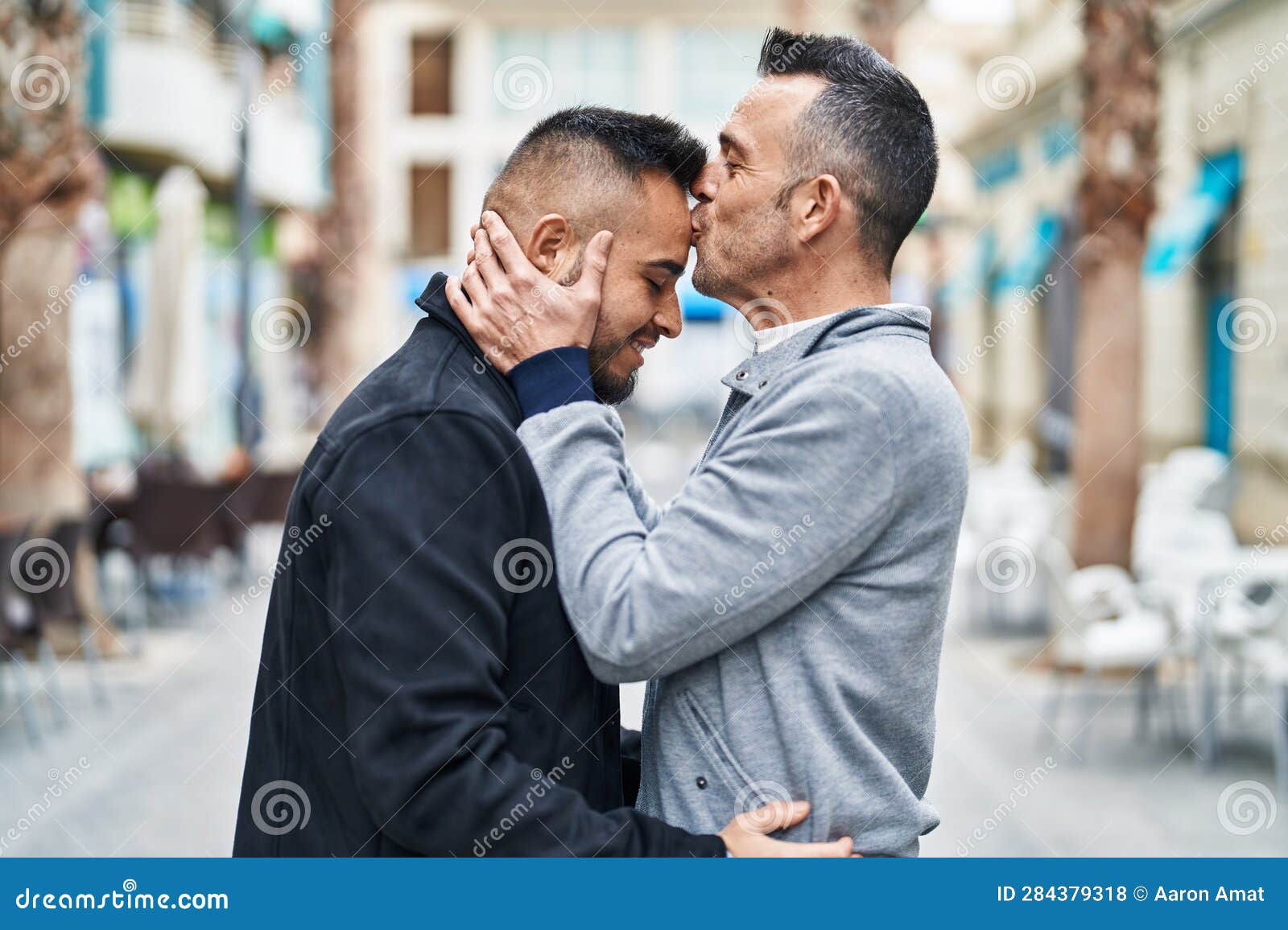 Two Men Couple Hugging Each Other Kissing At Coffee Shop Terrace Stock