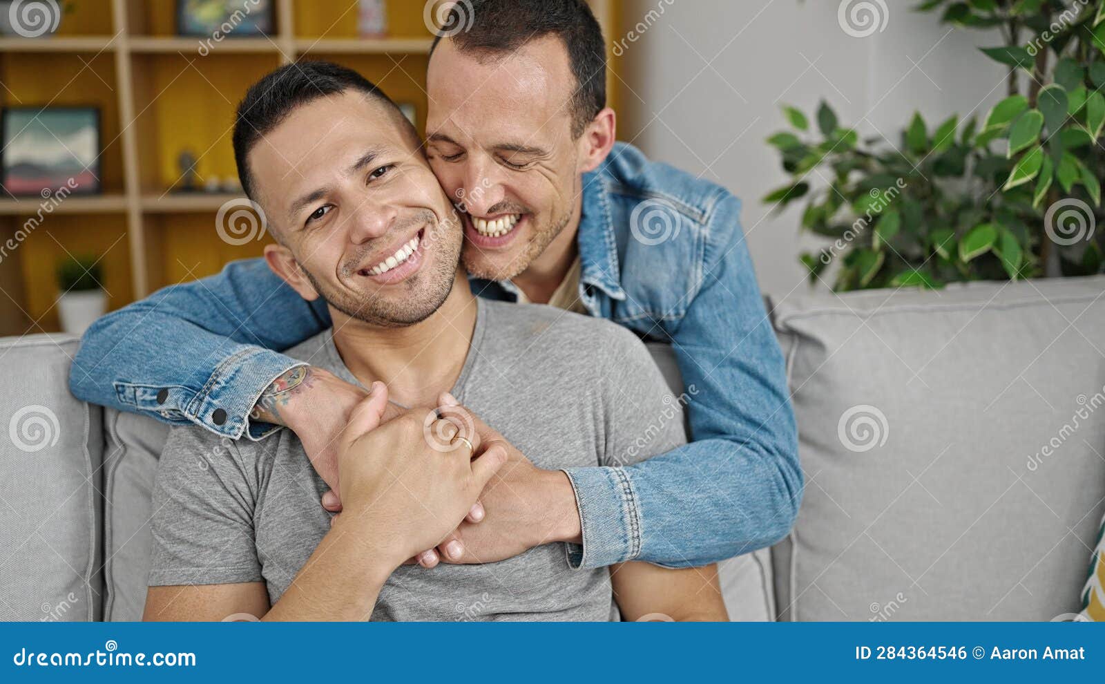 Two Men Couple Hugging Each Other Sitting on Sofa at Home Stock Photo ...