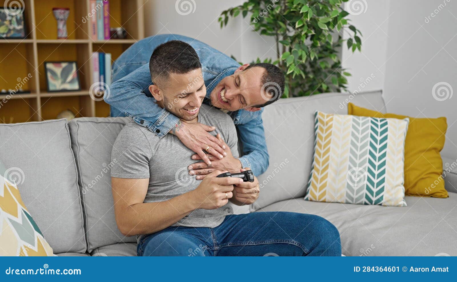 Two Men Couple Playing Video Game Hugging Each Other at Home Stock ...