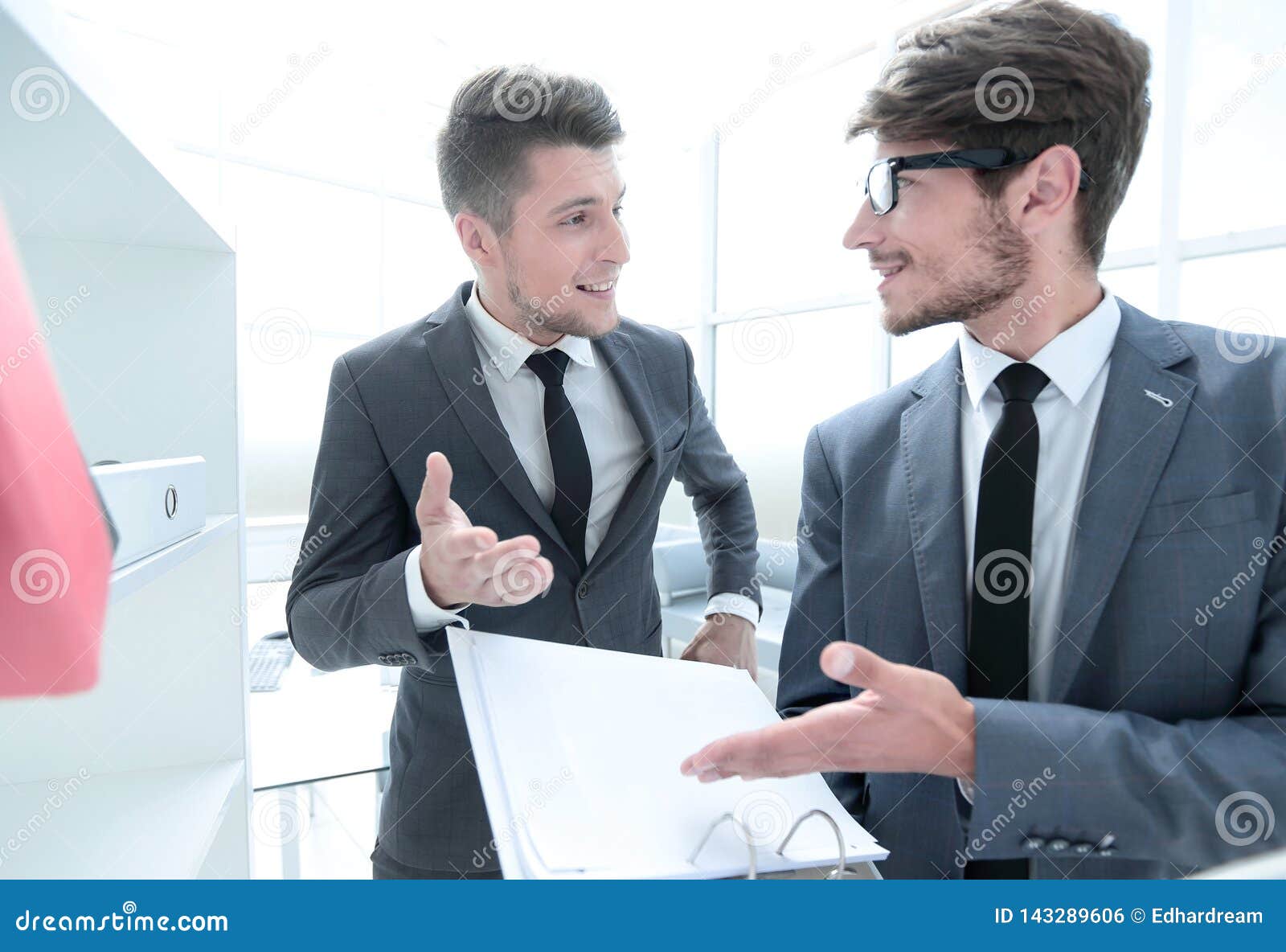 Two Men Discuss Information in a Folder with Documents Stock Photo ...