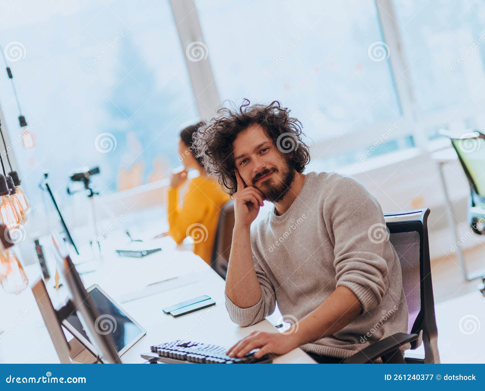 Two Men Discuss a Project while Looking at a Computer Monitor in a ...