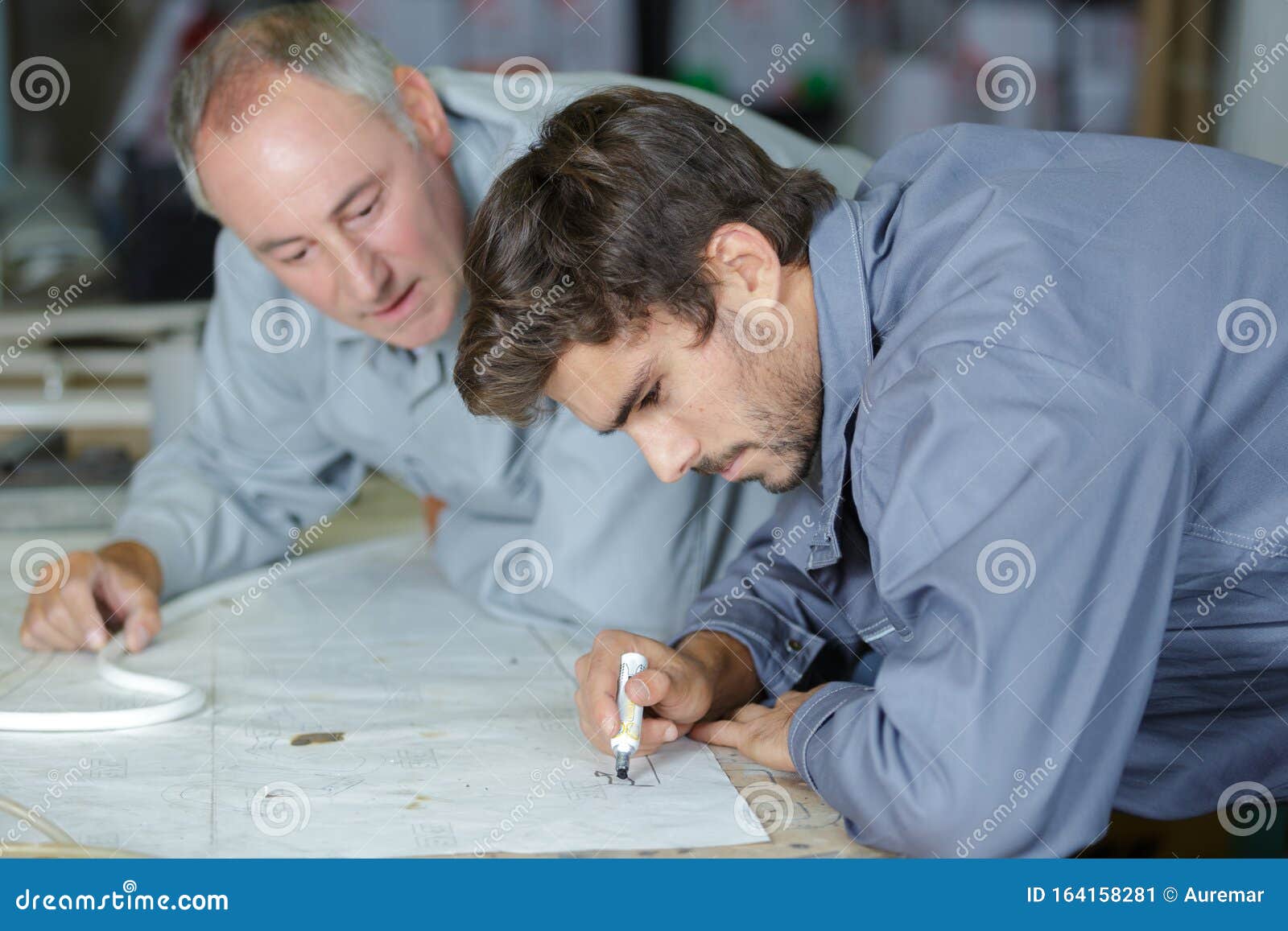 Two men discussing drawing stock image. Image of shopfloor - 164158281