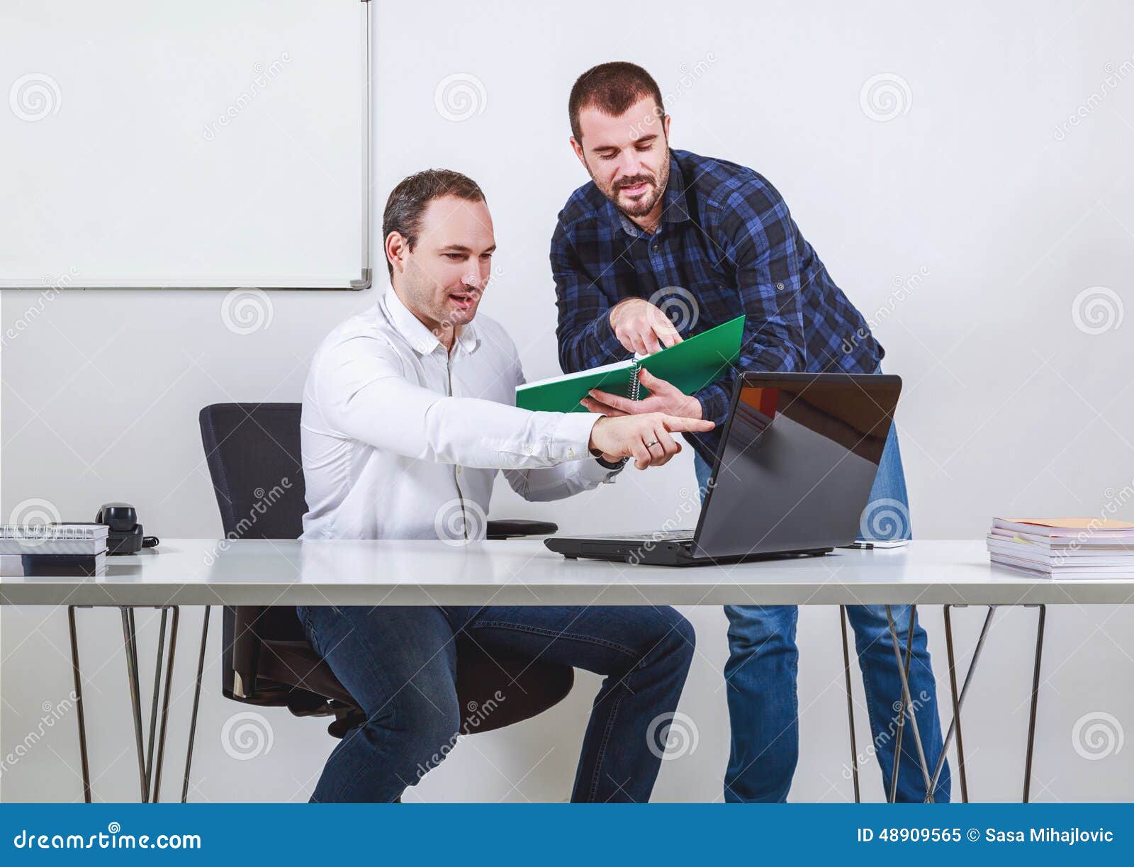 Two Men Discussing and Pointing at Computer and Note Book Stock Image ...