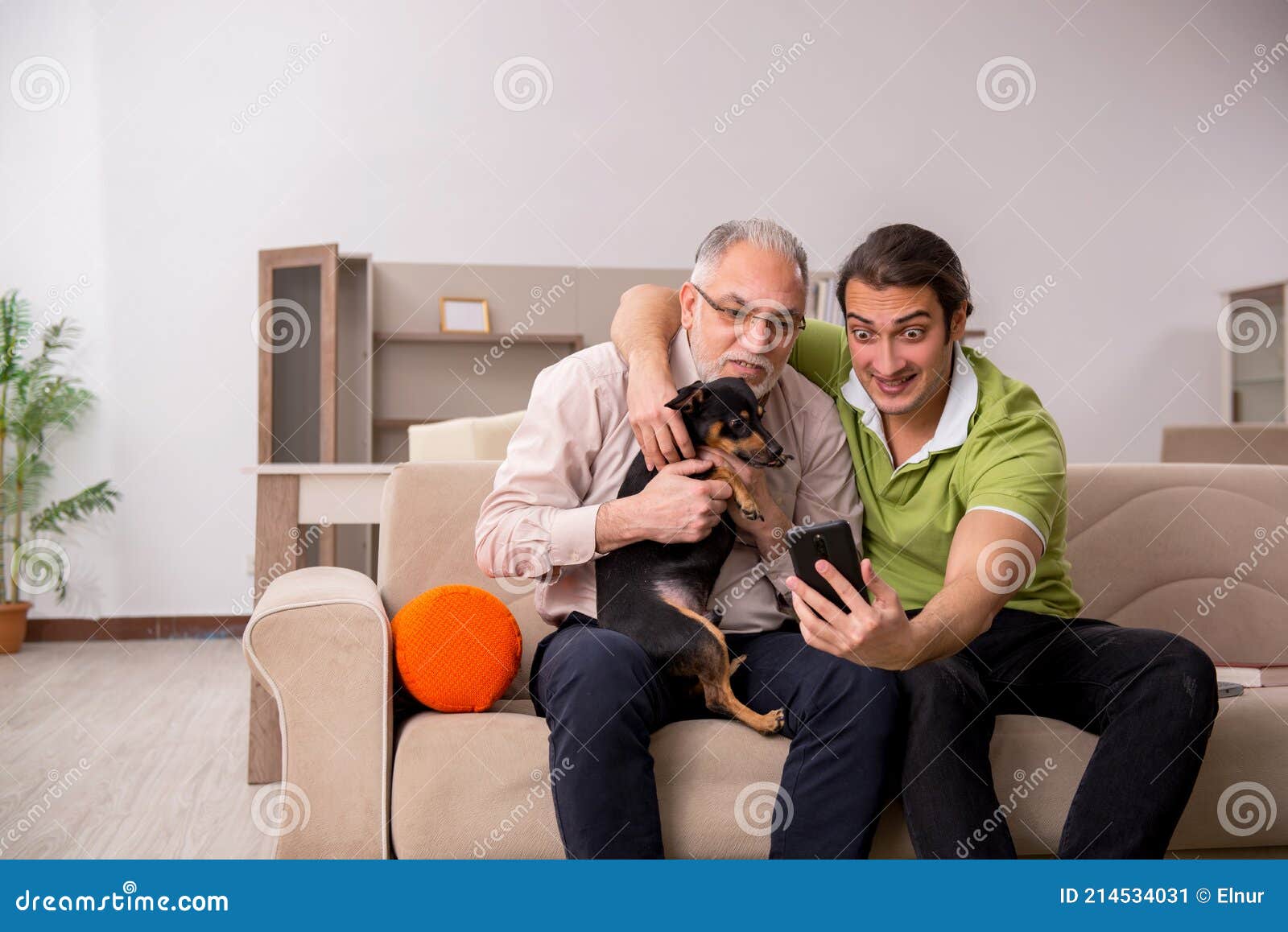 Two men with dog at home stock image. Image of parent - 214534031