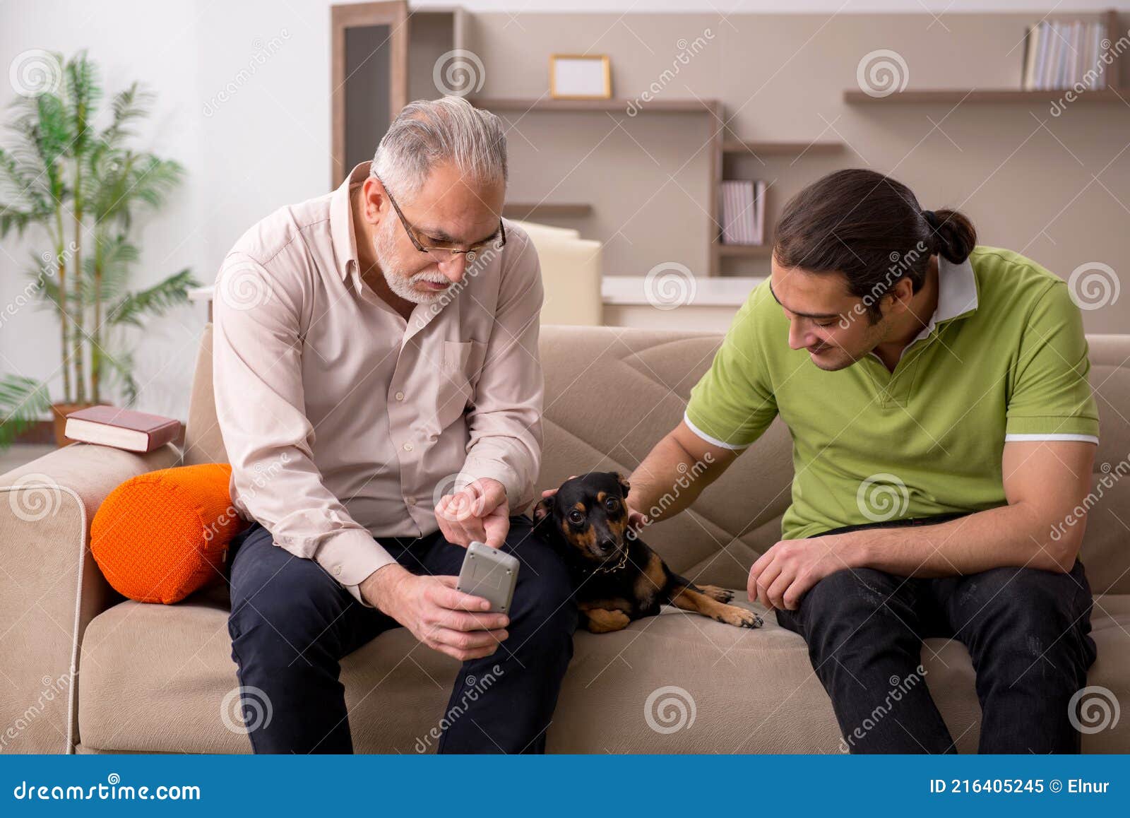 Two men with dog at home stock image. Image of animal - 216405245
