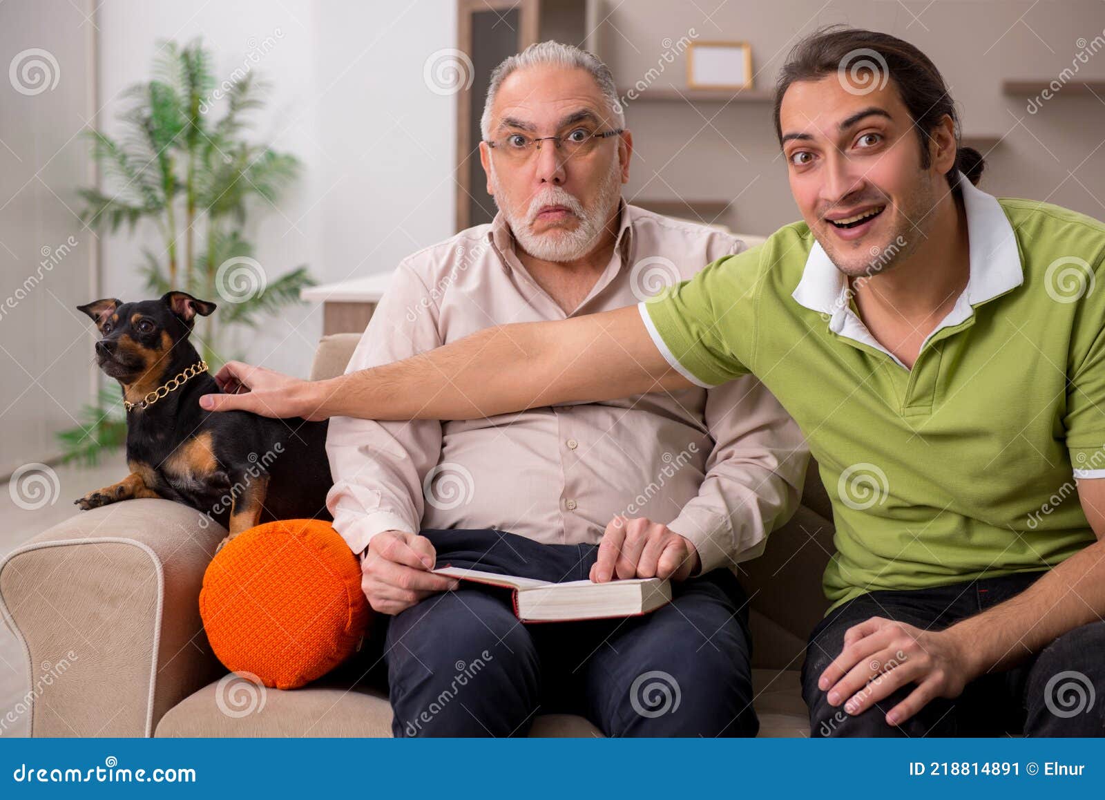 Two men with dog at home stock image. Image of young - 218814891