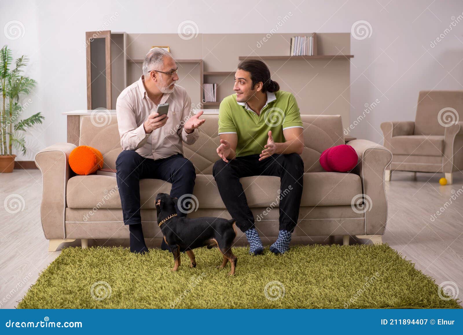 Two men with dog at home stock image. Image of parent - 211894407