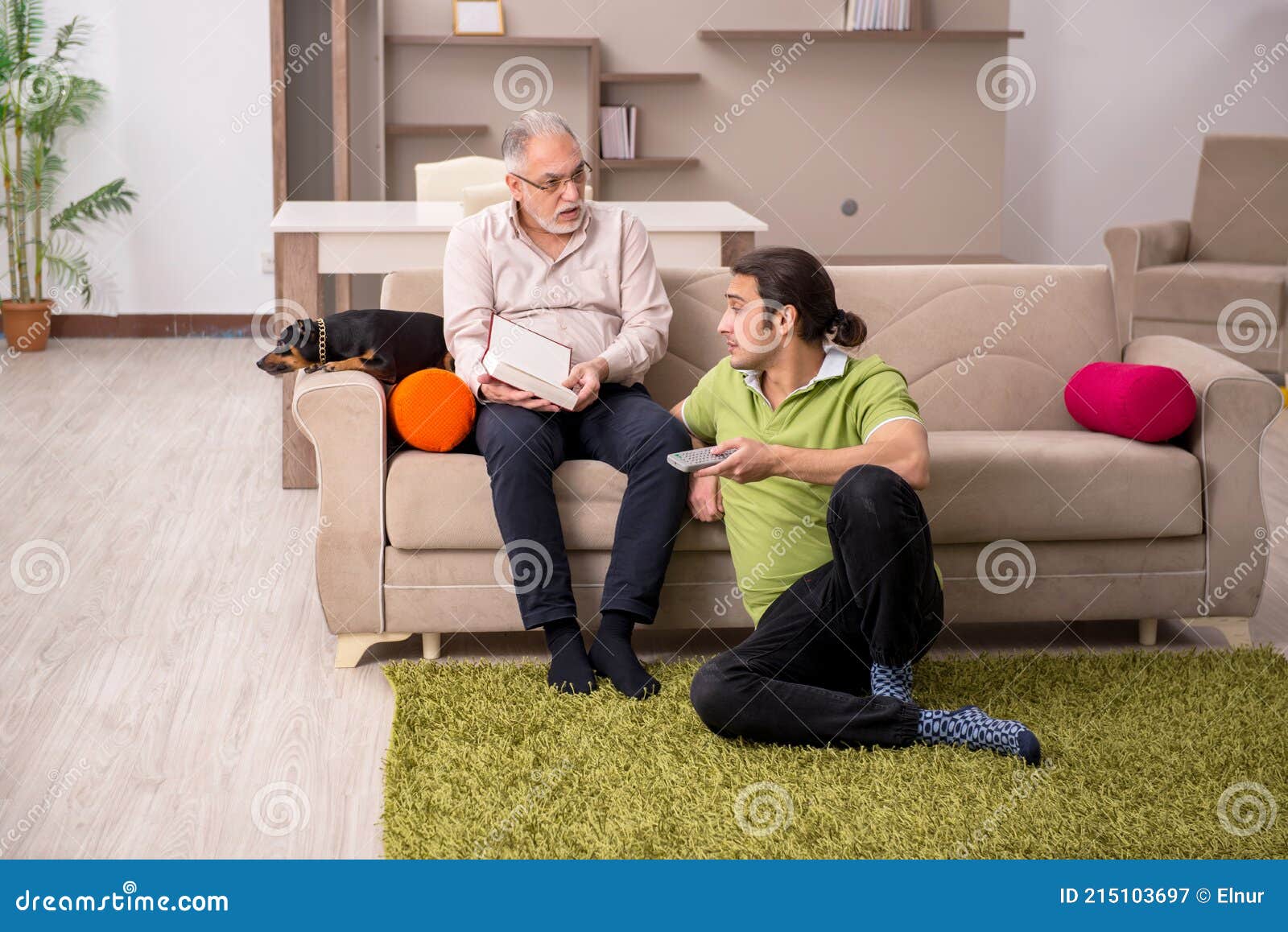 Two men with dog at home stock image. Image of book - 215103697