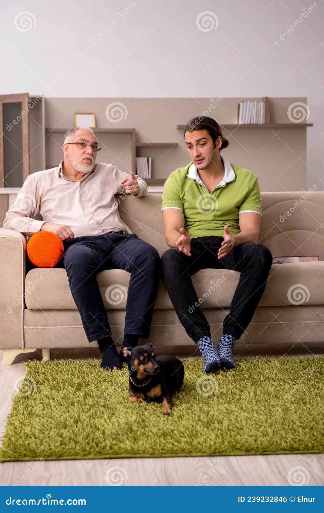 Two men with dog at home stock photo. Image of family - 239232846