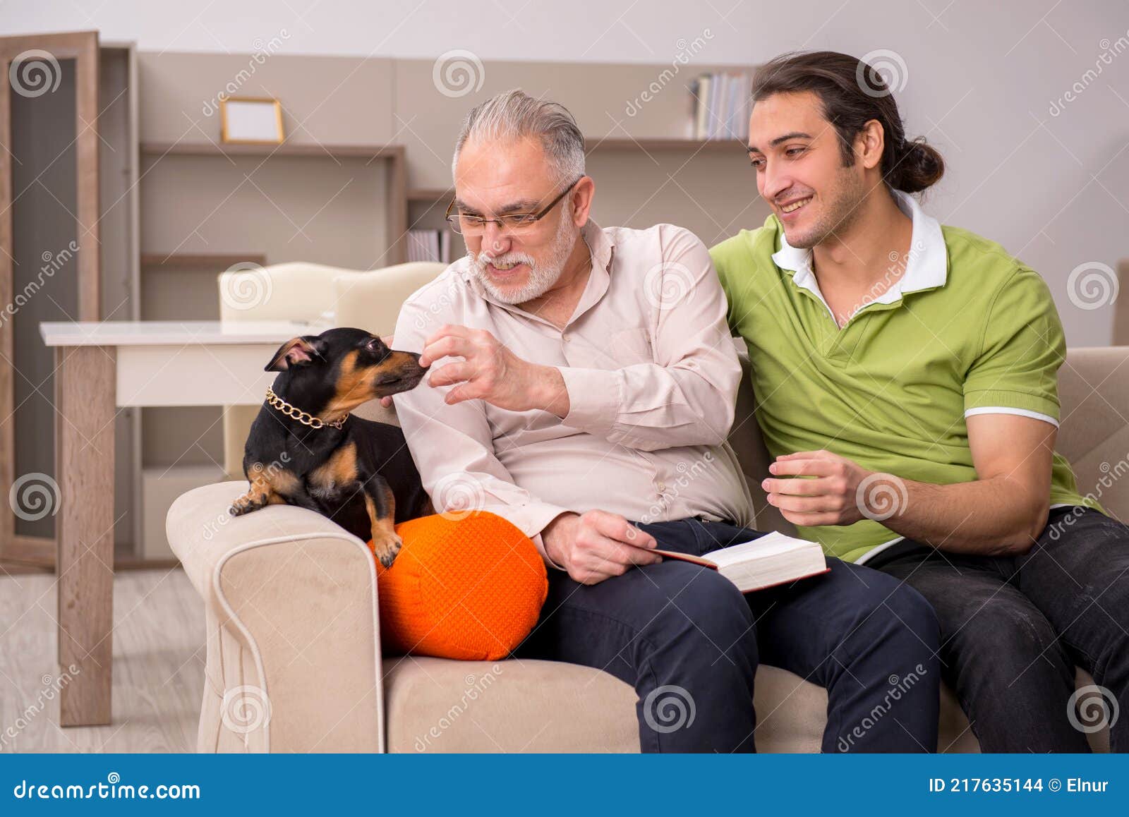 Two men with dog at home stock photo. Image of loyal - 217635144