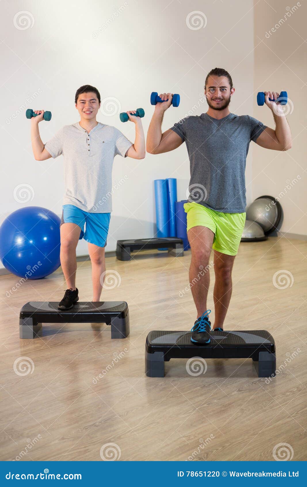 Two Men Doing Step Aerobic Exercise with Dumbbell on Stepper Stock ...