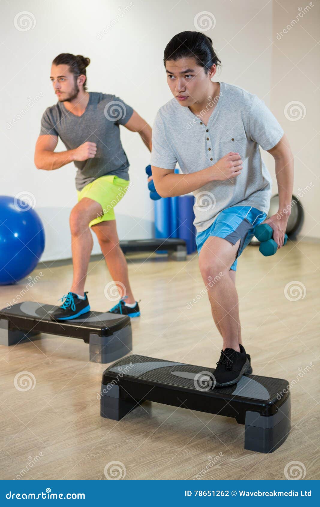 Two Men Doing Step Aerobic Exercise with Dumbbell on Stepper Stock ...