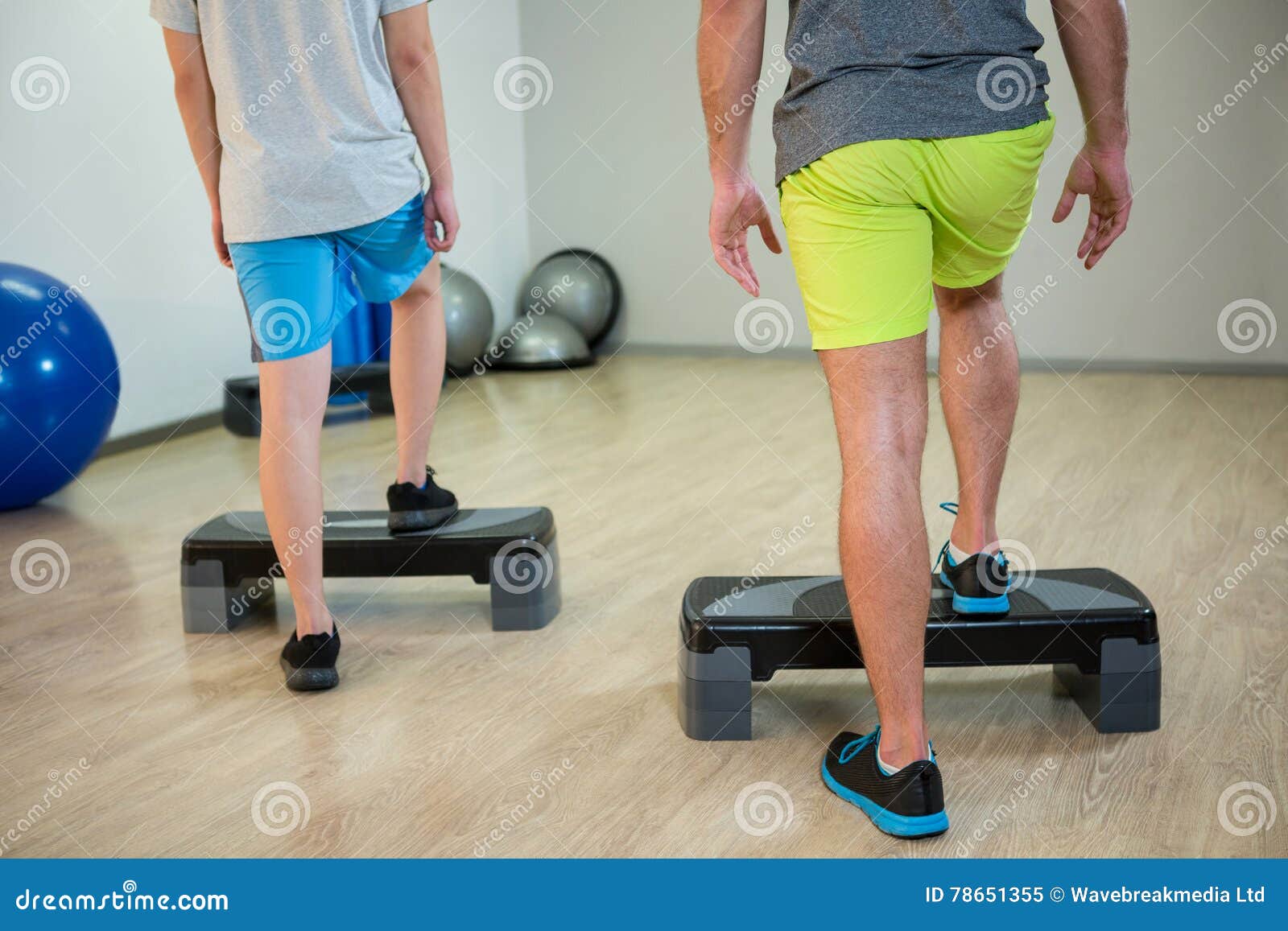 Two Men Doing Step Aerobic Exercise with Dumbbell on Stepper Stock ...