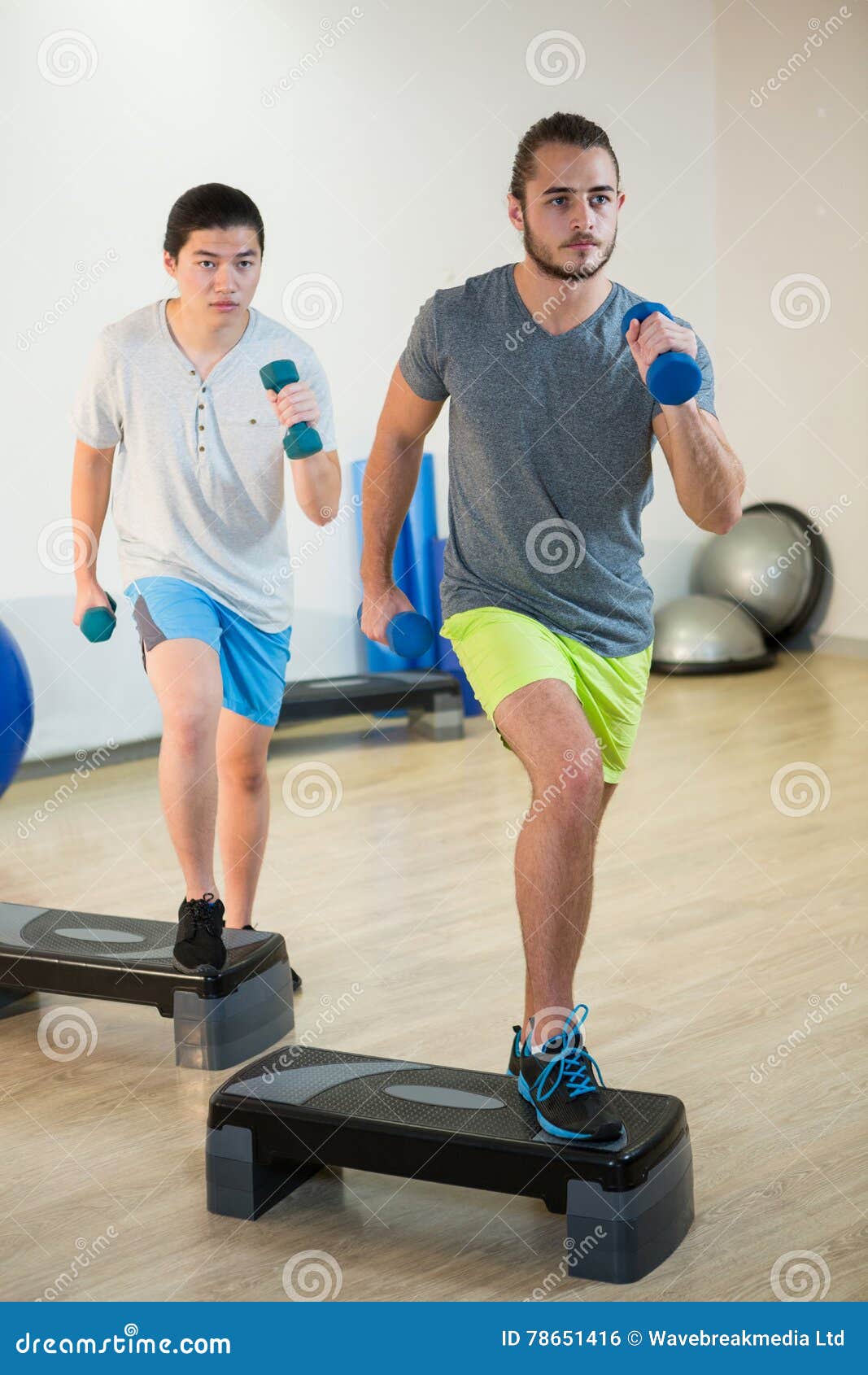 Two Men Doing Step Aerobic Exercise with Dumbbell on Stepper Stock ...