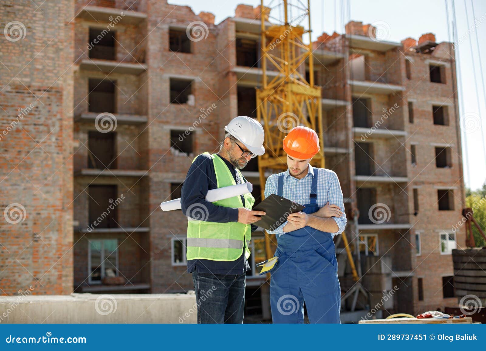 Two Men Engineers at a Construction Site are Looking at the Drawings ...