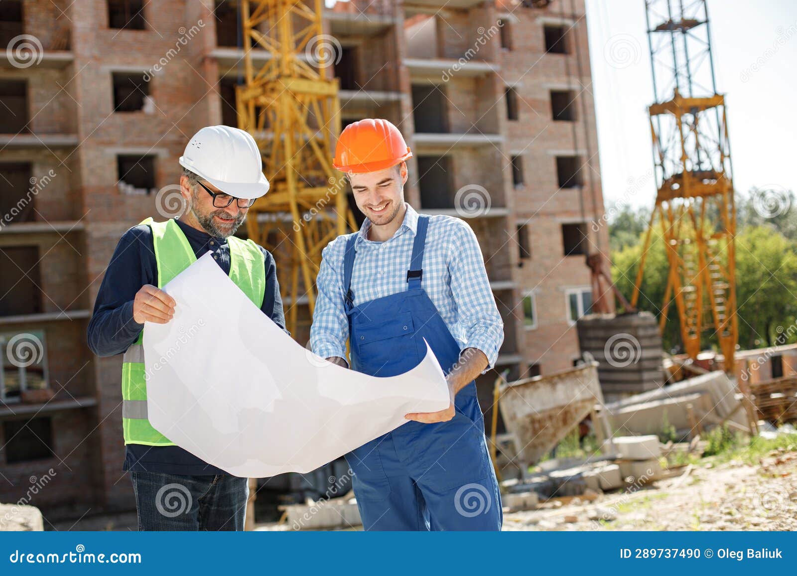 Two Men Engineers at a Construction Site are Looking at the Drawings ...