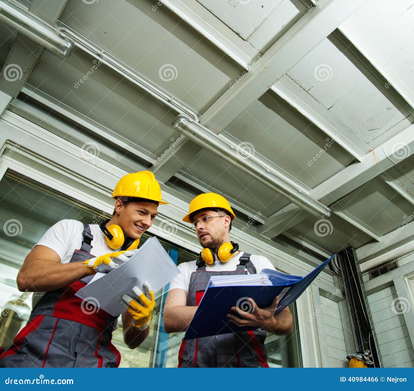 Two men on a factory stock photo. Image of helmet, check - 40984466