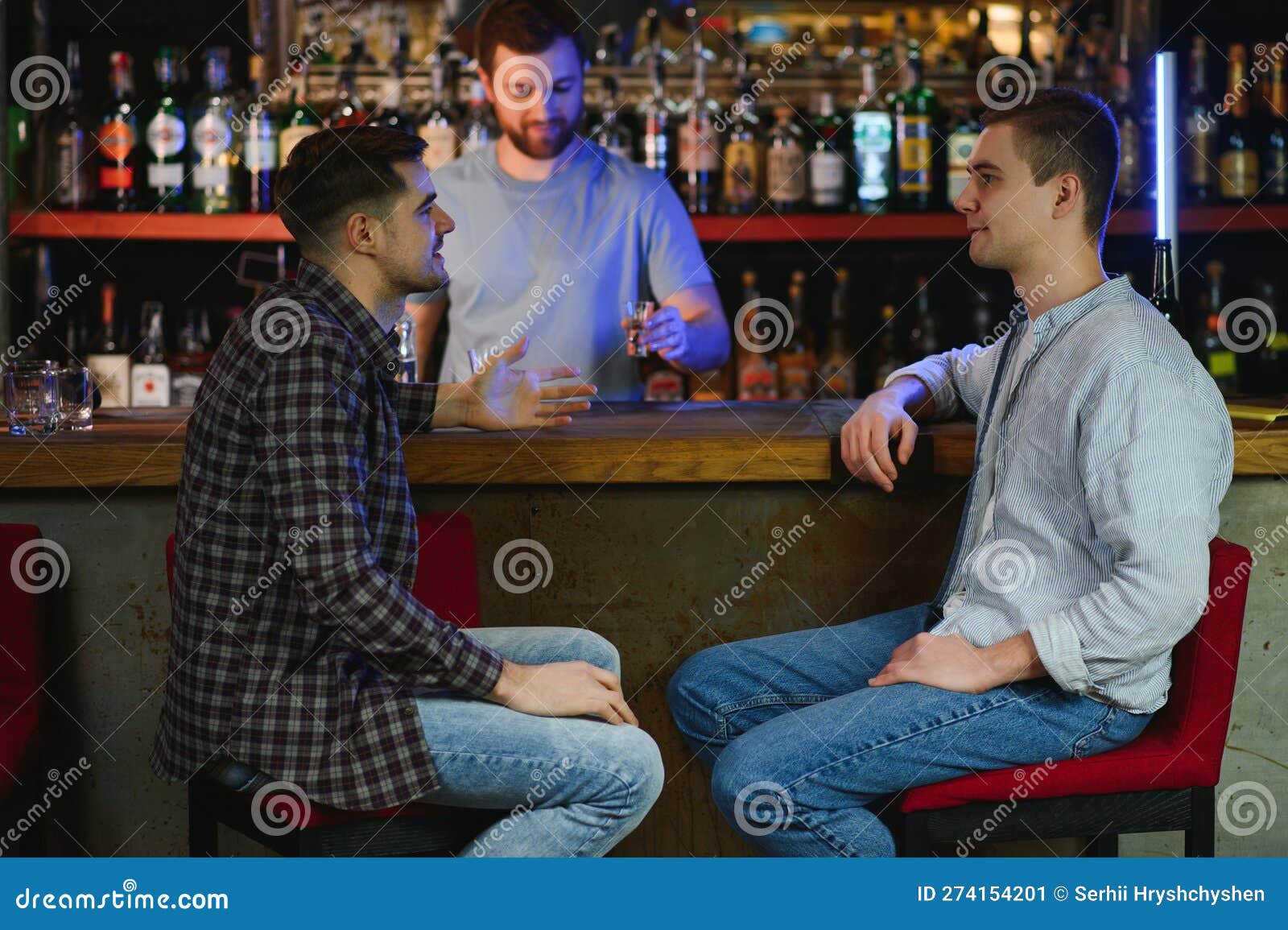 Two Men is Having Fun Chatting with a Bartender in Bar Counter while ...