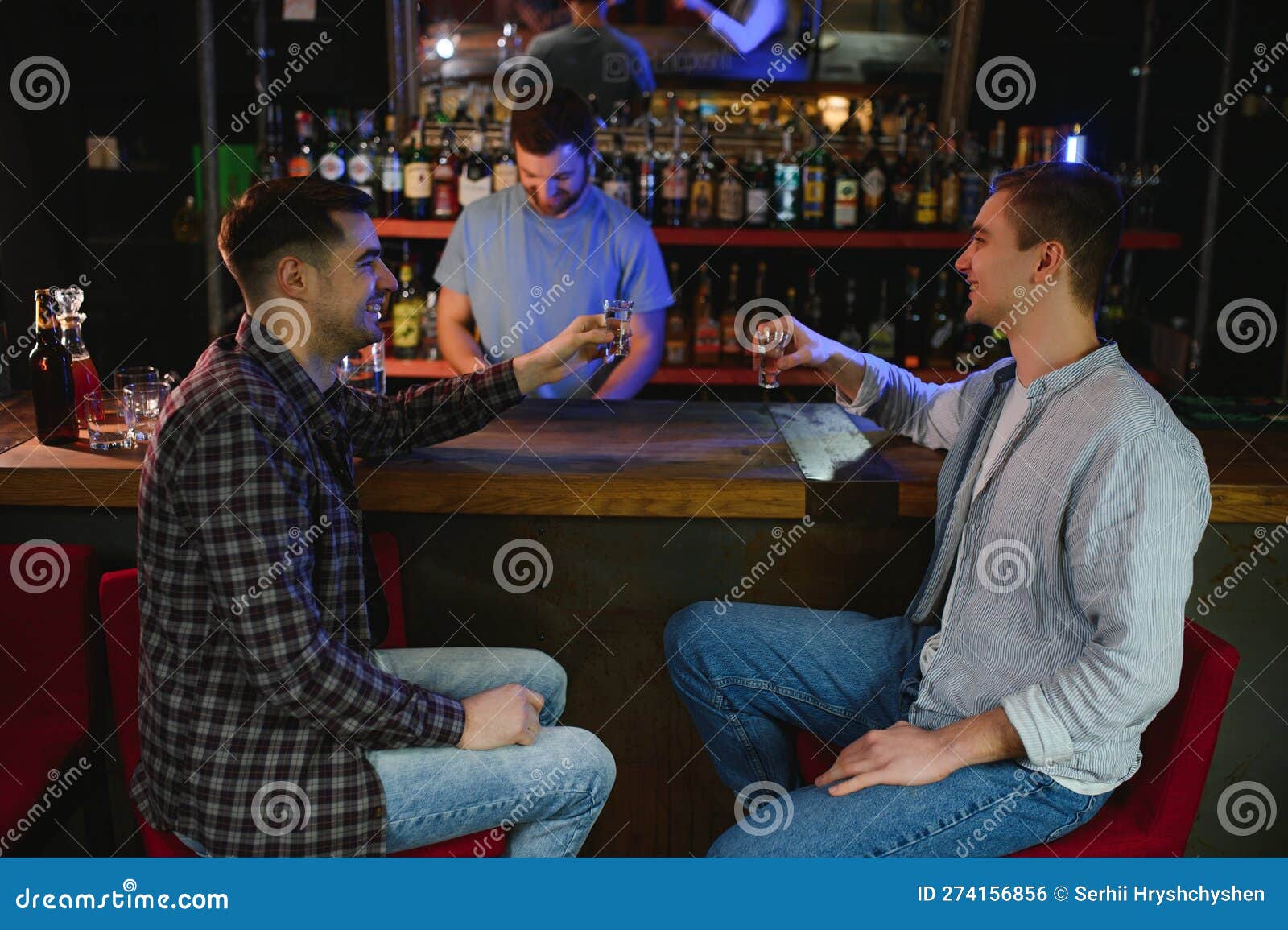 Two Men is Having Fun Chatting with a Bartender in Bar Counter while ...