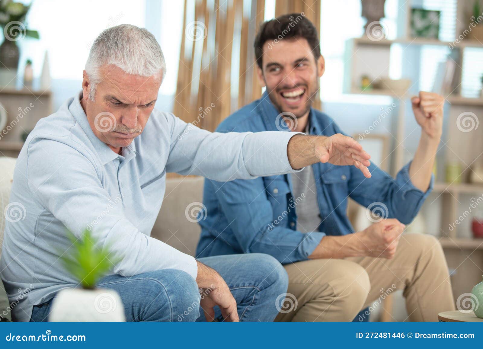 Two Men at Home Making Arm Gestures Stock Photo - Image of confident ...