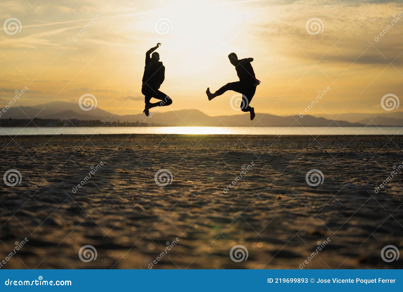 Two Men Jumping on the Beach at Sunset Stock Image - Image of sunset ...