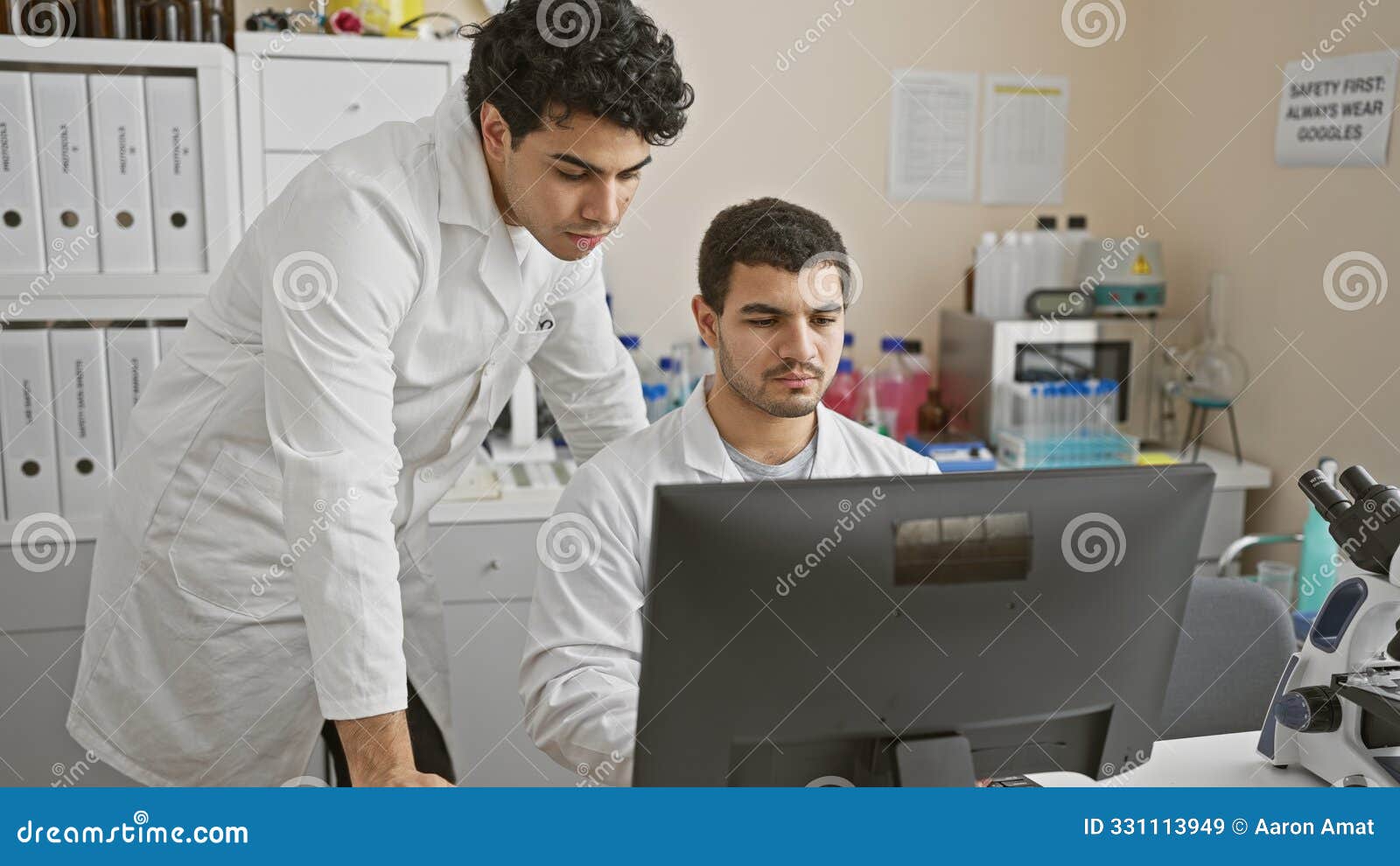 Two Men in Lab Coats Working Together at a Computer in a Scientific ...