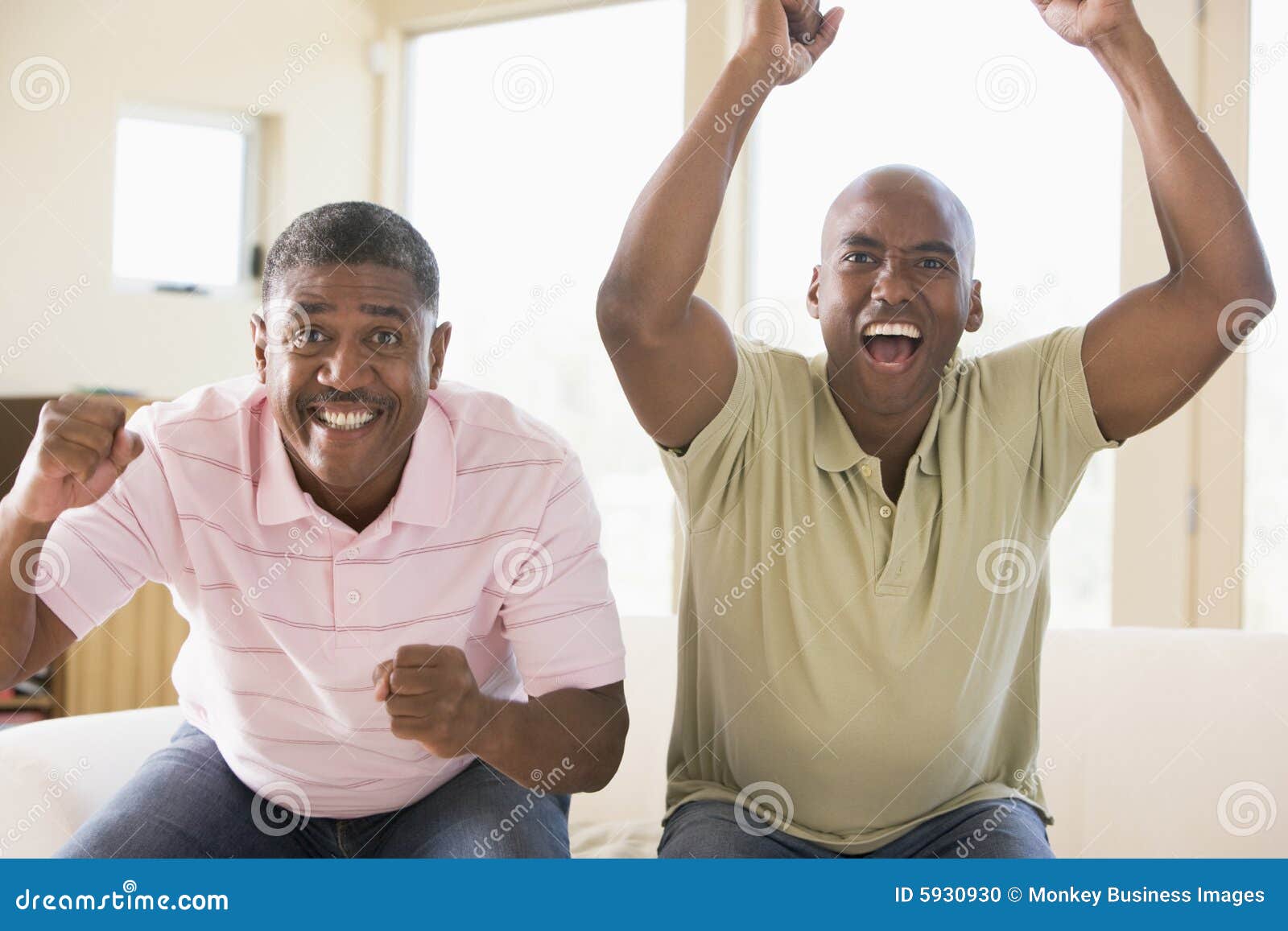 Two Men in Living Room Cheering and Smiling Stock Photo - Image of ...