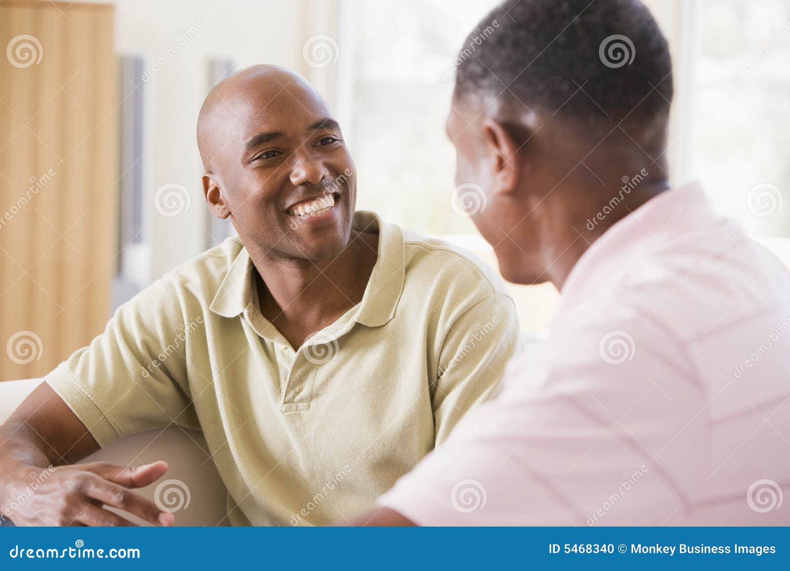 Two Men in Living Room Talking and Smiling Stock Photo - Image of ...