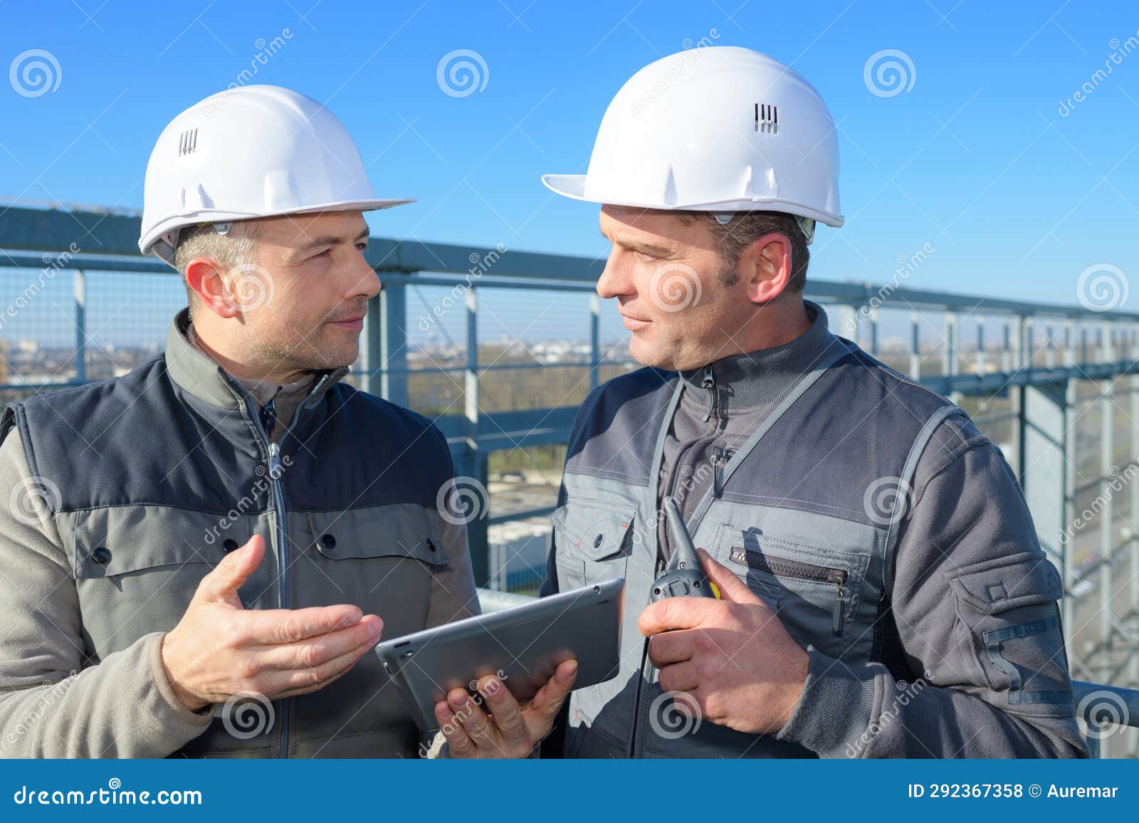 Two Men Looking at Tablet Pc by Perimeter Fence Stock Photo - Image of ...